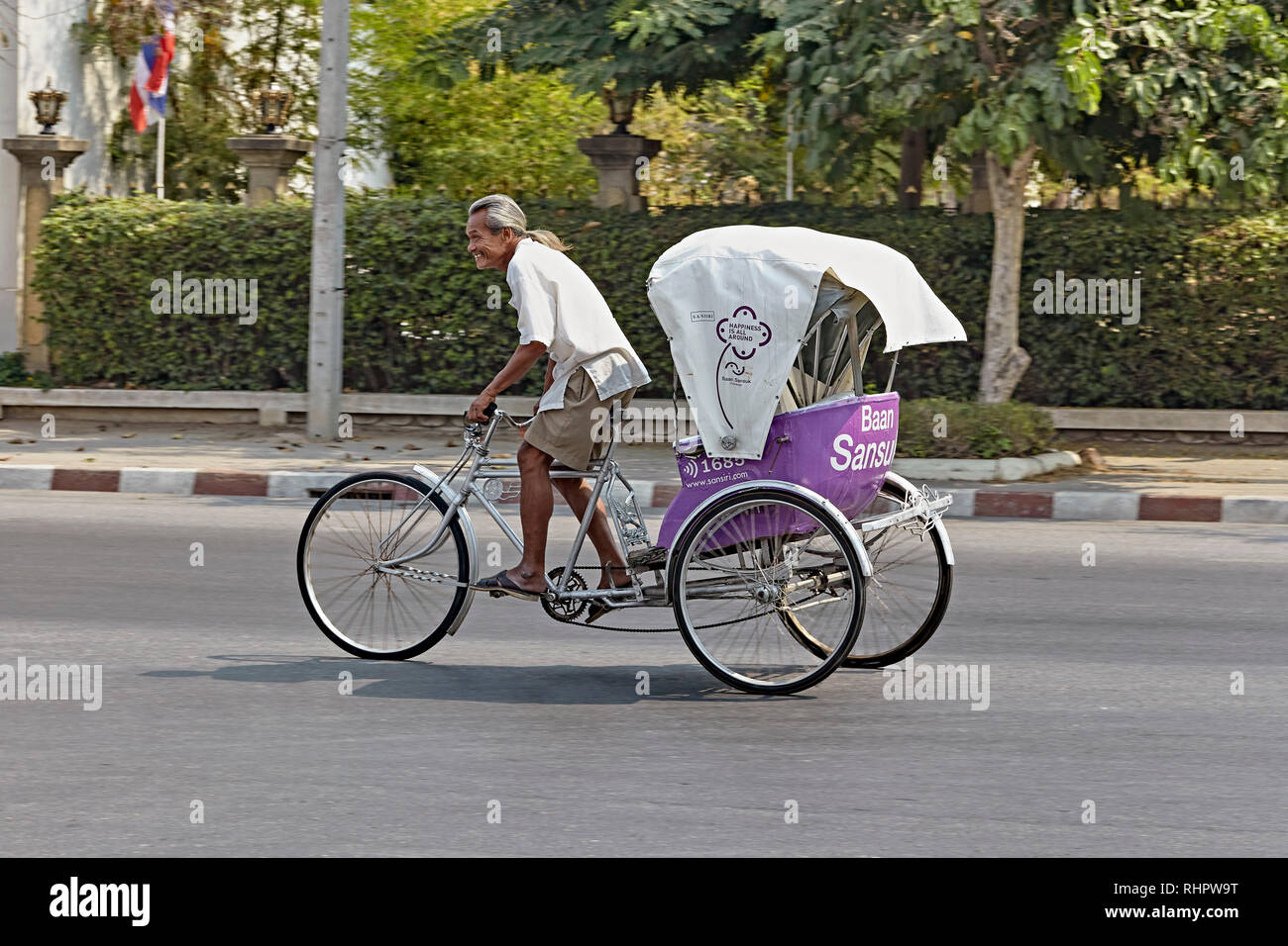 Rickshaw driver speeding along the road. Thailand Samlor bicycle taxi ...