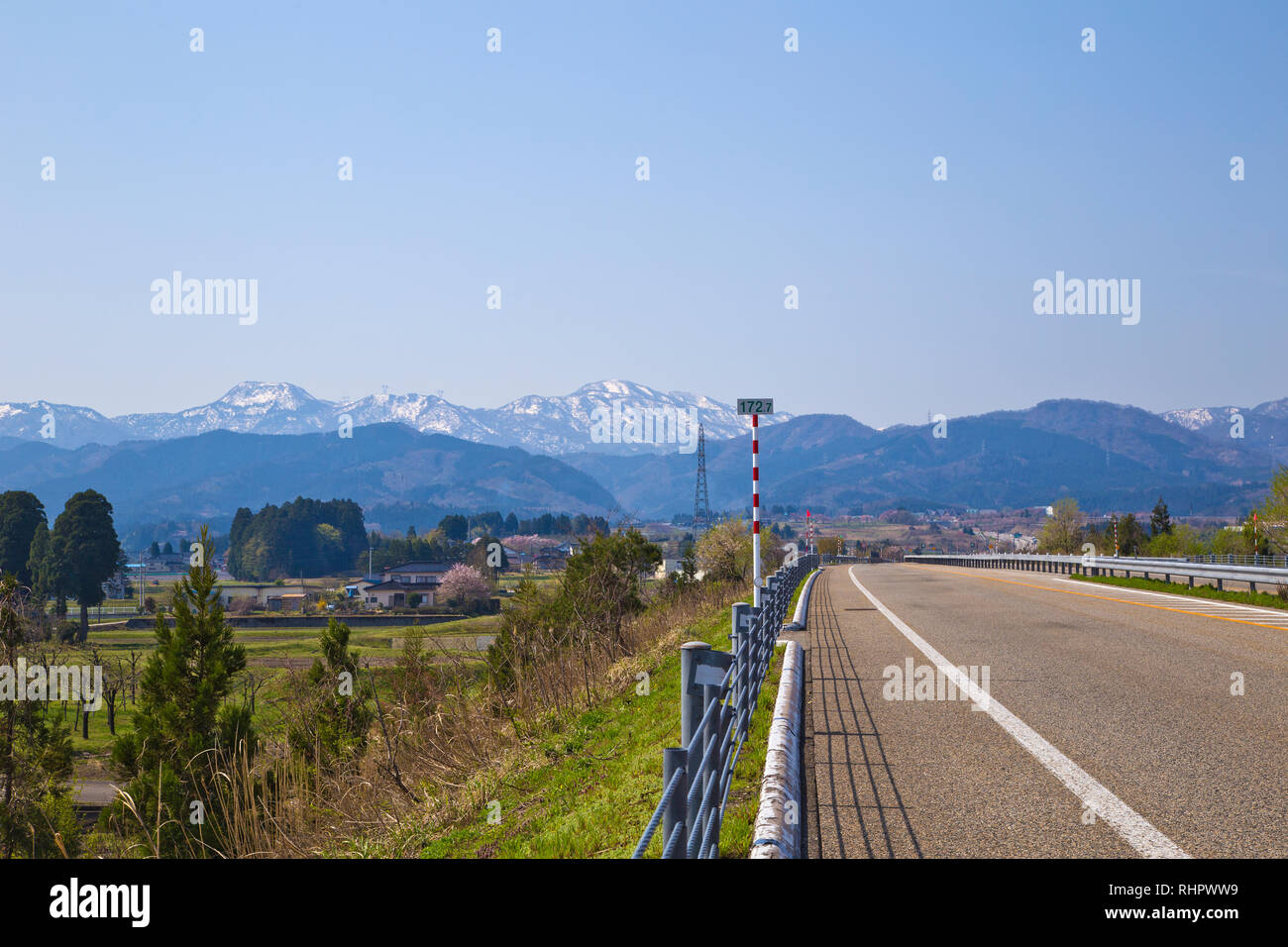 View of countryside road with Japan Alps mountain in the background ...