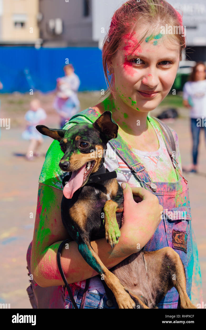 Teenagers on the Holi festival. Young girl with her dog in colorful ...