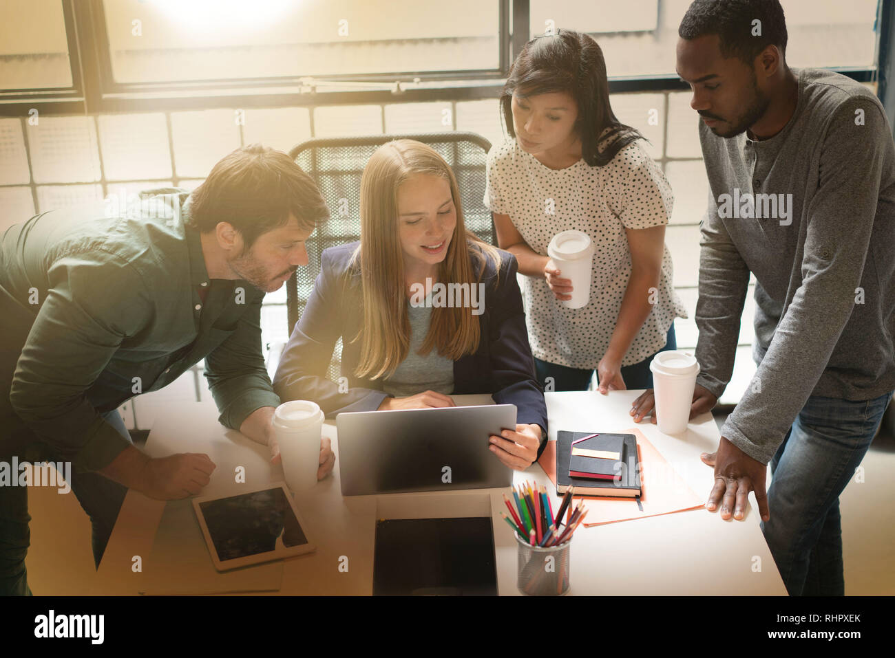Group of co workers being shown latest presentation by young attractive ...