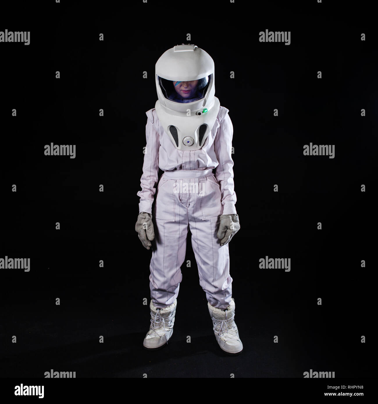 Astronaut in a space suit stands quietly among the black void. Human in ...