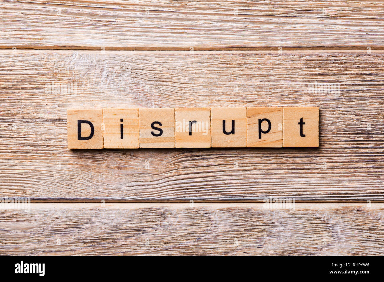 DISRUPT word written on wood block. DISRUPT text on wooden table for ...