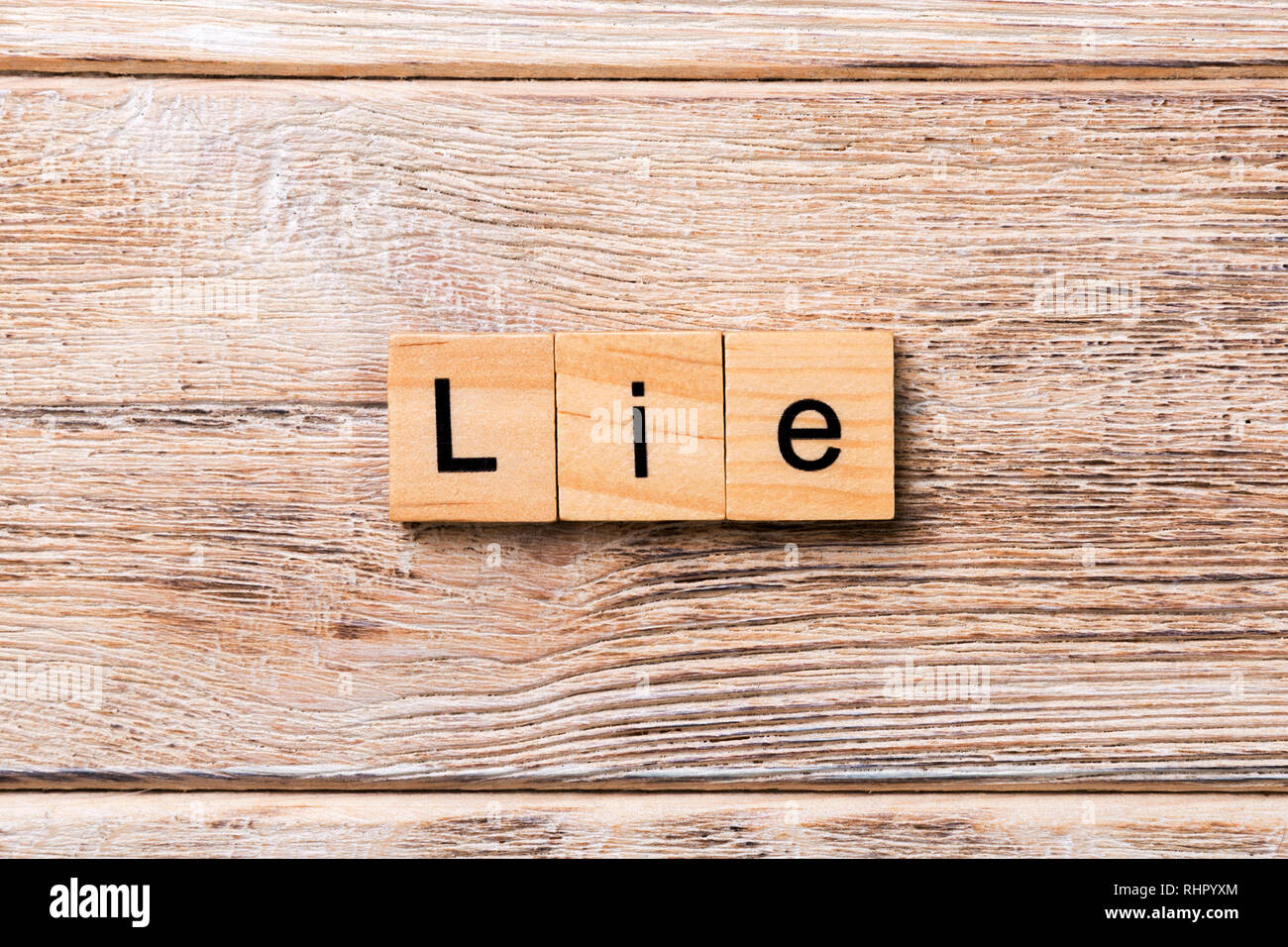 LIE word written on wood block. LIE text on wooden table for your ...
