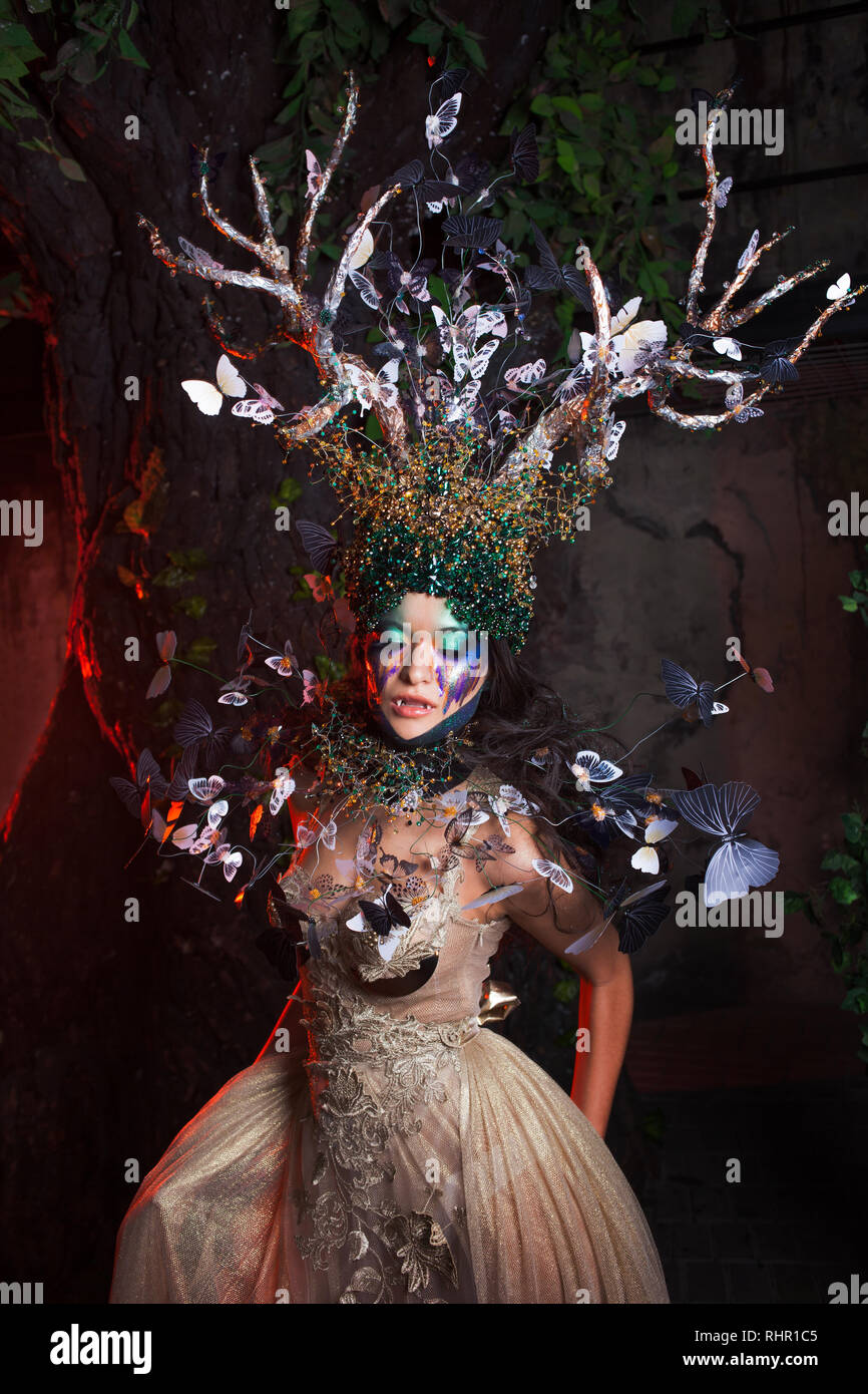 Natural nymph with horns like branches of a tree and butterflies ...