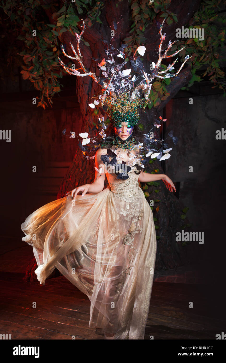 Natural nymph with horns like branches of a tree and butterflies ...