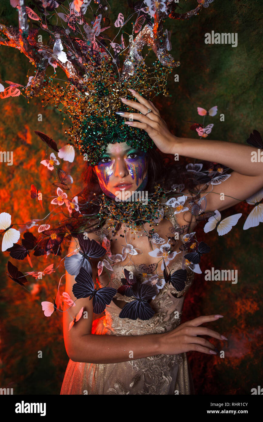 Natural nymph with horns like branches of a tree and butterflies ...