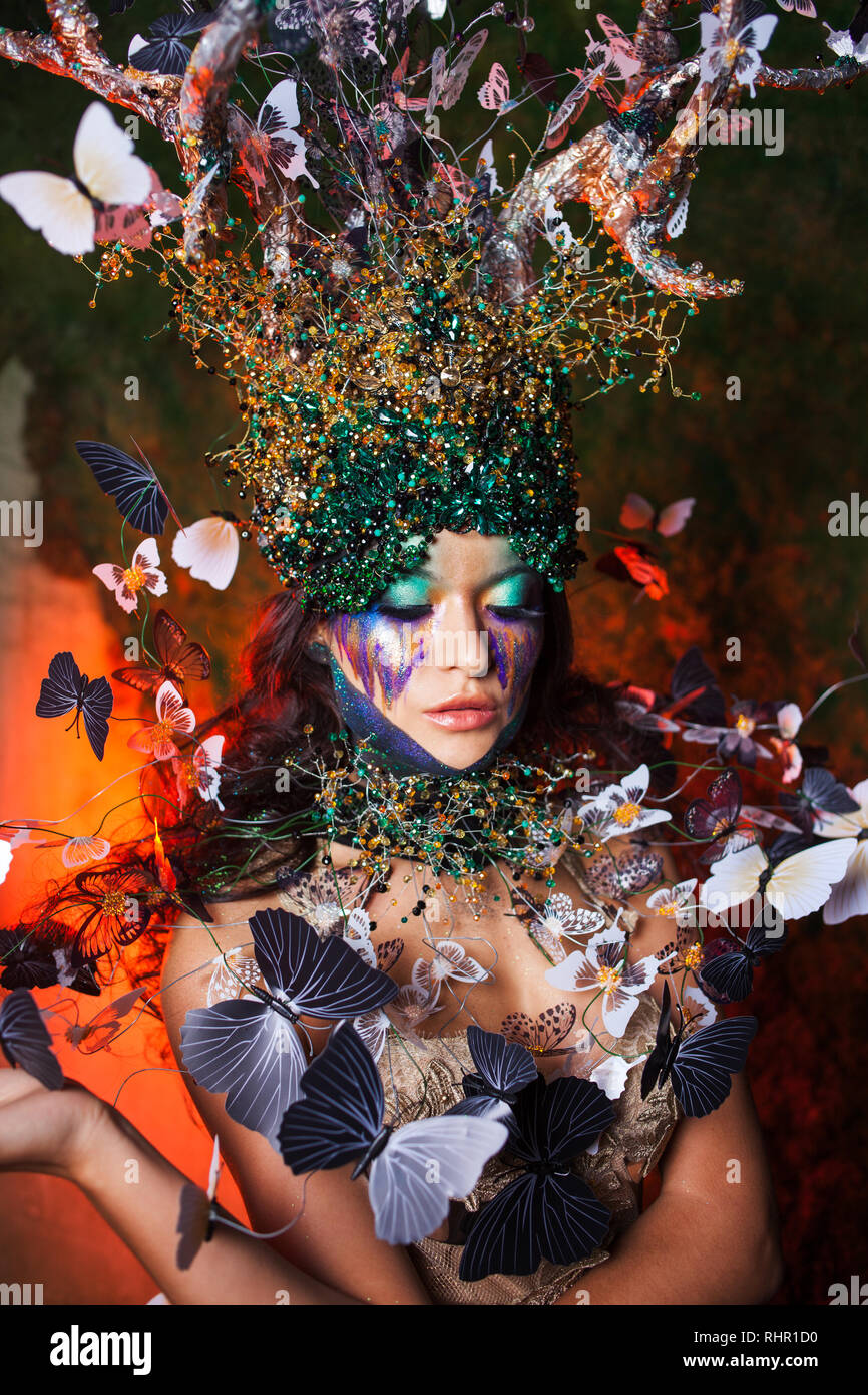 Natural nymph with horns like branches of a tree and butterflies ...