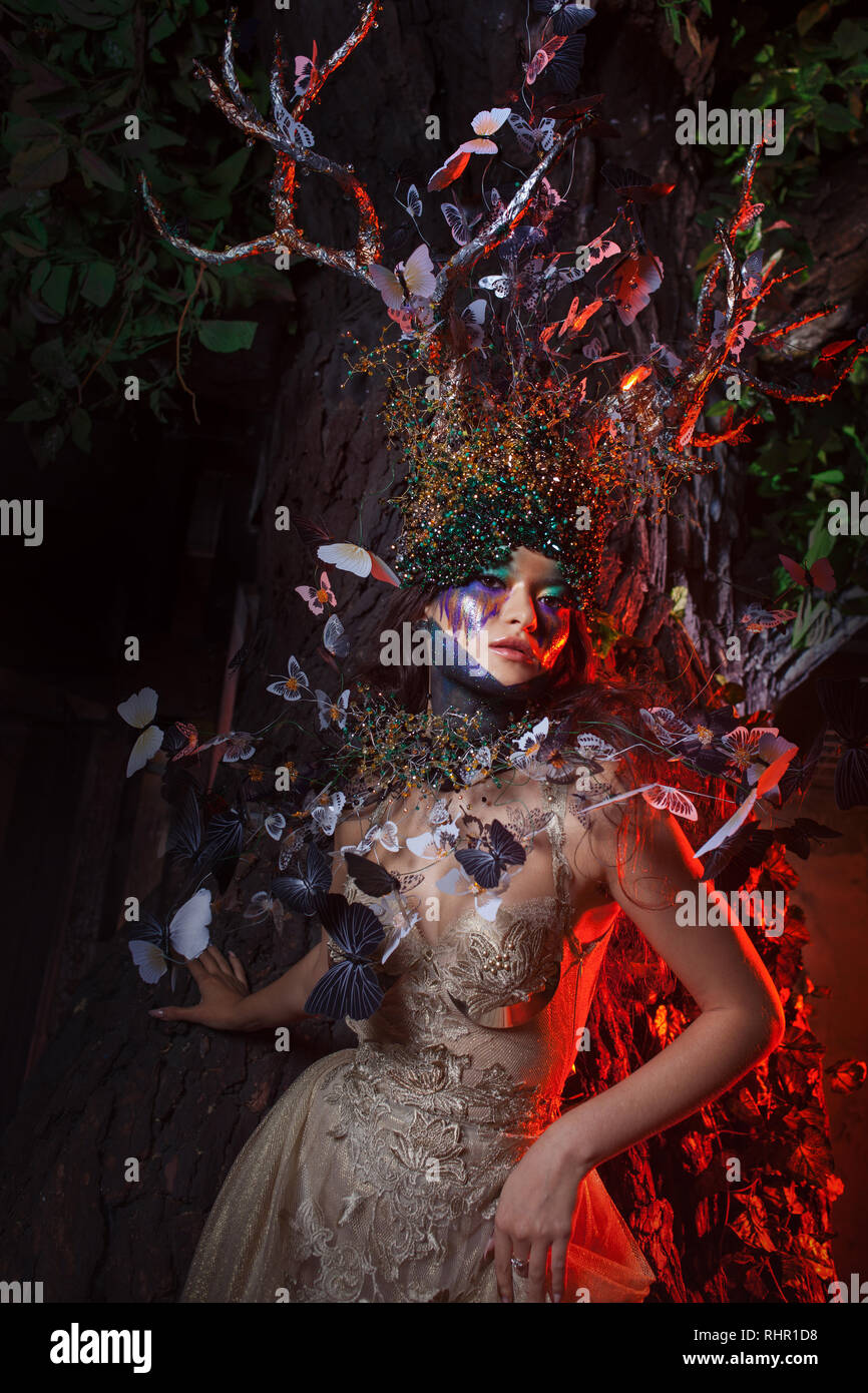 Natural nymph with horns like branches of a tree and butterflies ...