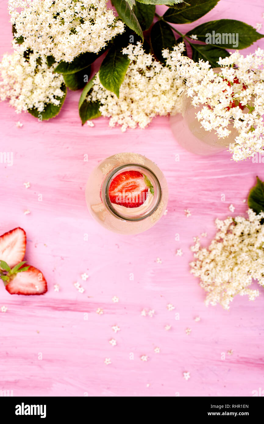 Kombucha tea with elderflower flower and strawberry on pink background ...