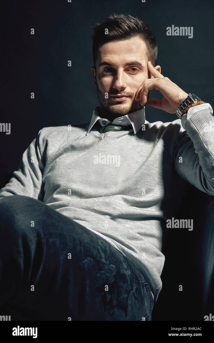 Young thoughtful man posing on dark background. Thinking concept Stock ...