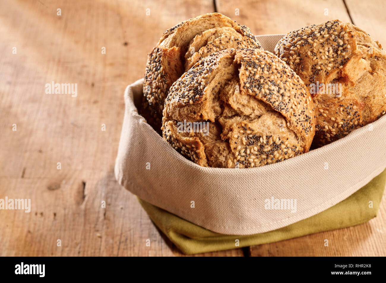 Fabric bag of fresh baked buns of dark wholewheat crunchy bread with ...