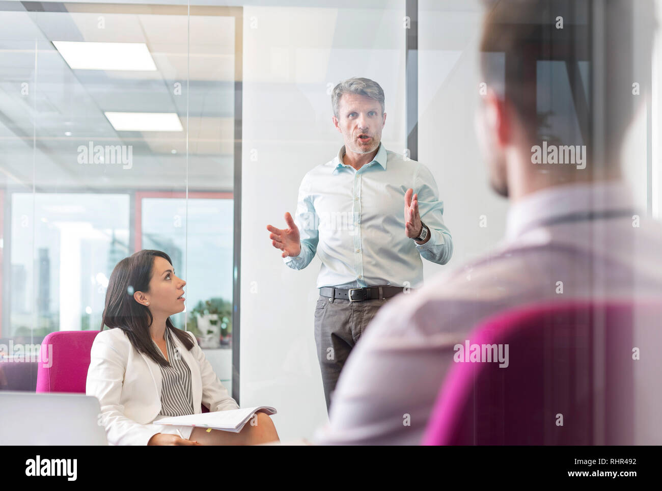 Manager explaining colleagues in office meeting Stock Photo - Alamy