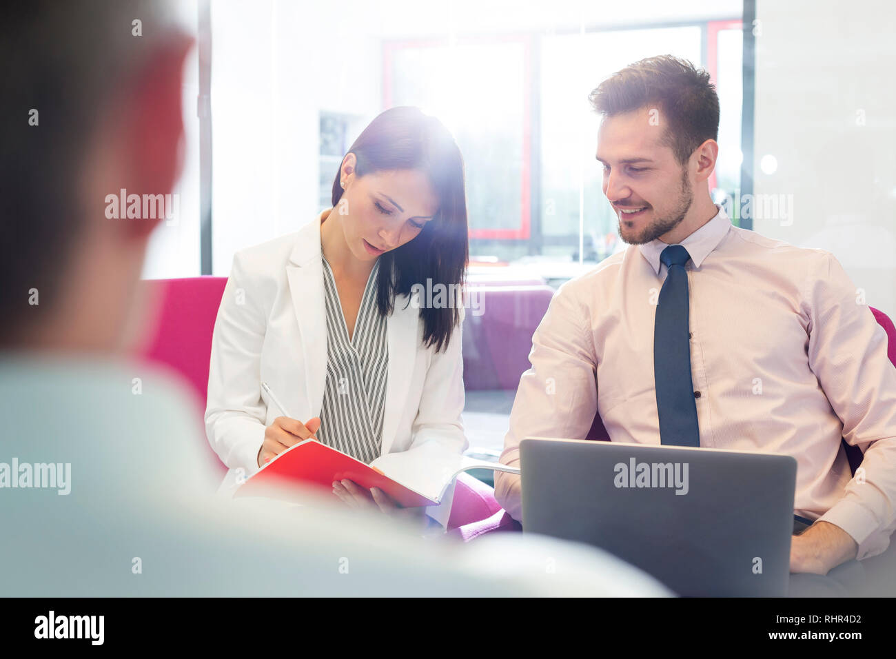 Business colleagues with laptop and file discussing in meeting at ...