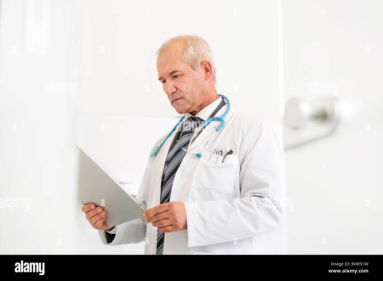 Doctor reading report hi-res stock photography and images - Alamy