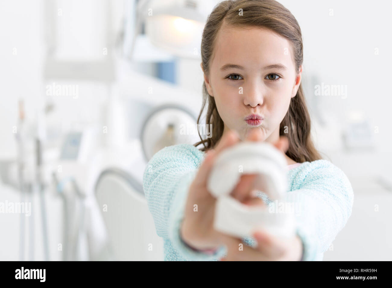Closeup of girl showing dentures while making face at dental clinic ...