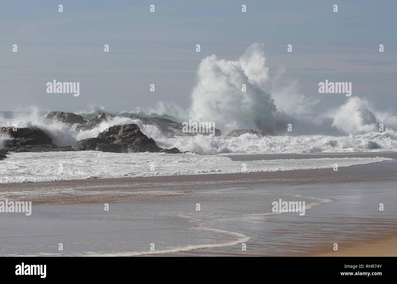 Sunny rocky sea beach with big wave splash Stock Photo - Alamy