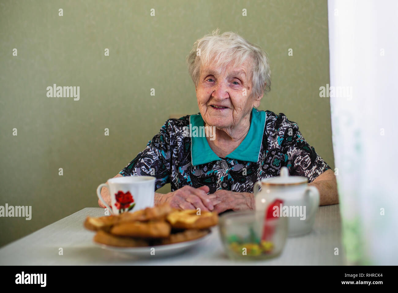 Elderly woman drinking tea in the kitchen Stock Photo - Alamy