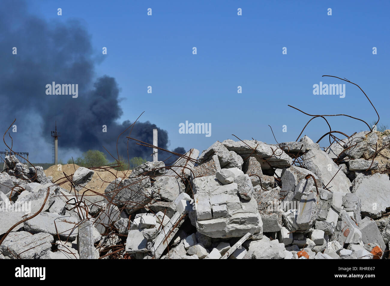 A pile of concrete rubble with protruding rebar on the background of ...