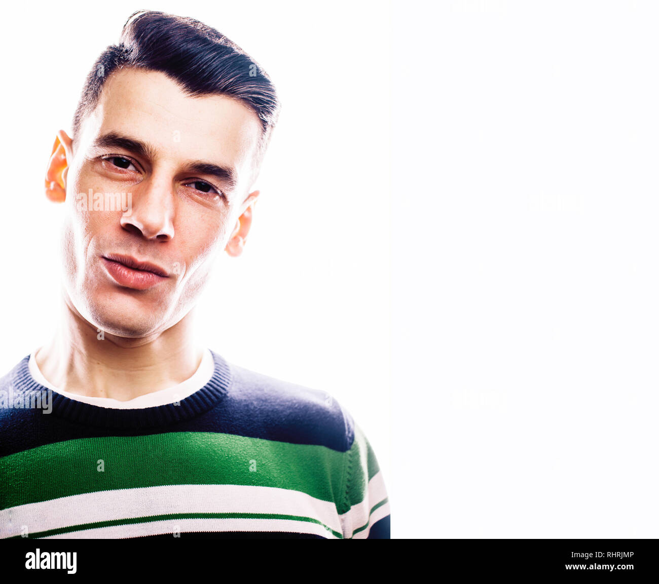 Portrait of a smart serious young man standing against white background ...
