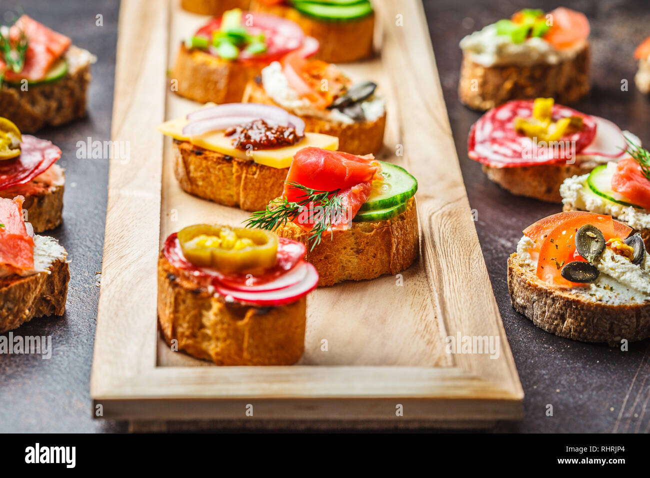 Assorted spanish tapas with fish, sausage, cheese and vegetables. Dark ...