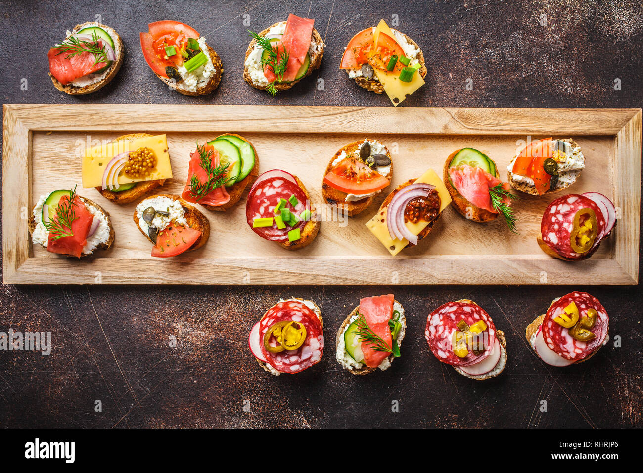 Assorted spanish tapas with fish, sausage, cheese and vegetables. Dark ...