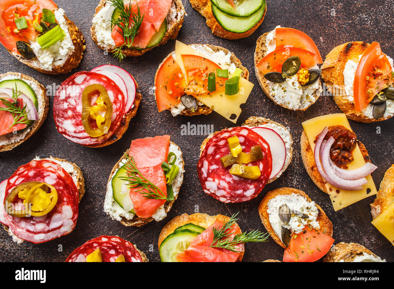 Assorted spanish tapas with fish, sausage, cheese and vegetables. Dark ...