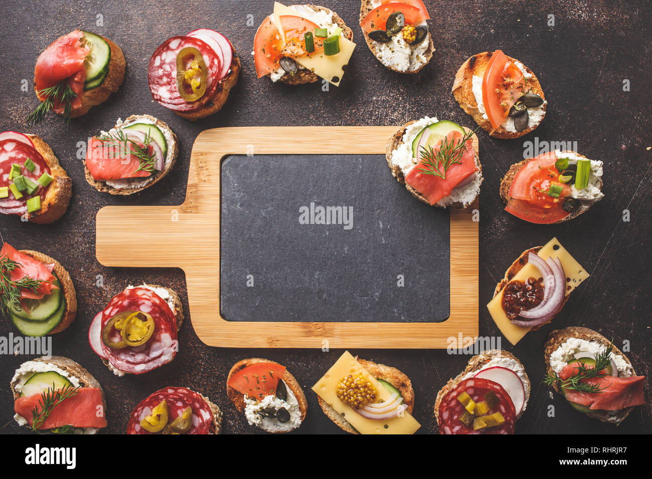 Assorted spanish tapas with fish, sausage, cheese and vegetables. Dark ...