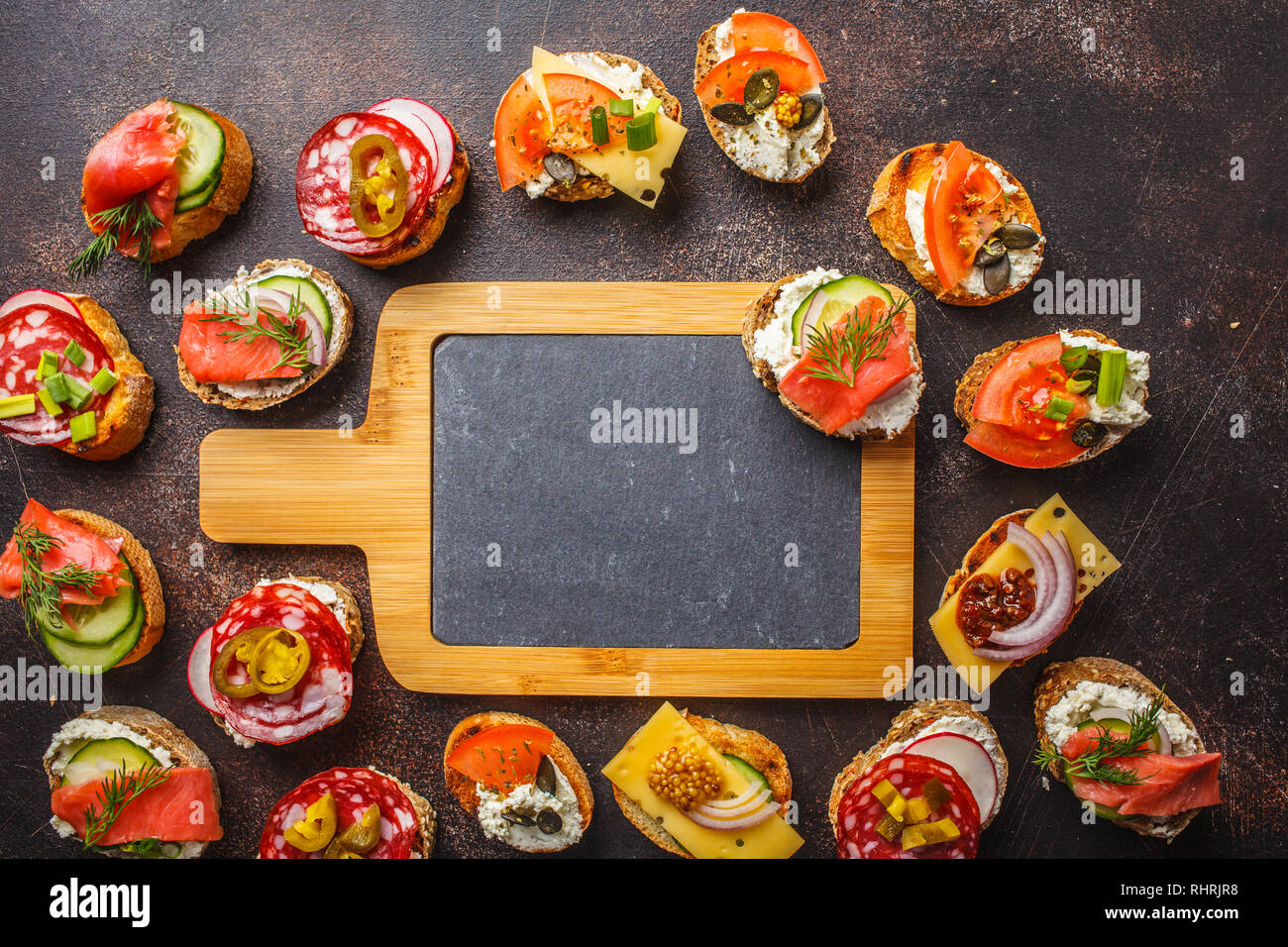 Assorted spanish tapas with fish, sausage, cheese and vegetables. Dark ...