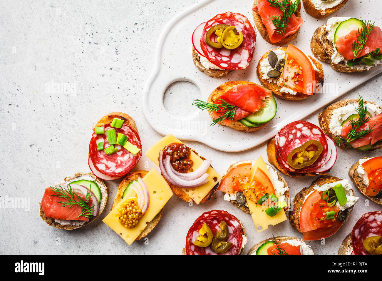 Assorted spanish tapas with fish, sausage, cheese and vegetables. White ...