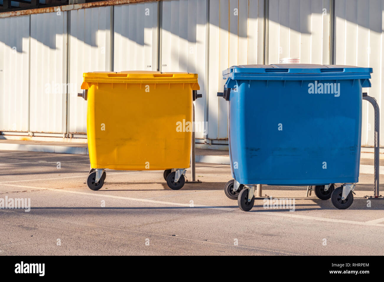 Garbage containers. Blue and yellow recycling containers Stock Photo ...