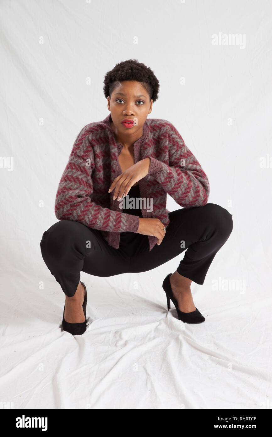 Lovely Black woman squatting thoughtfully Stock Photo - Alamy