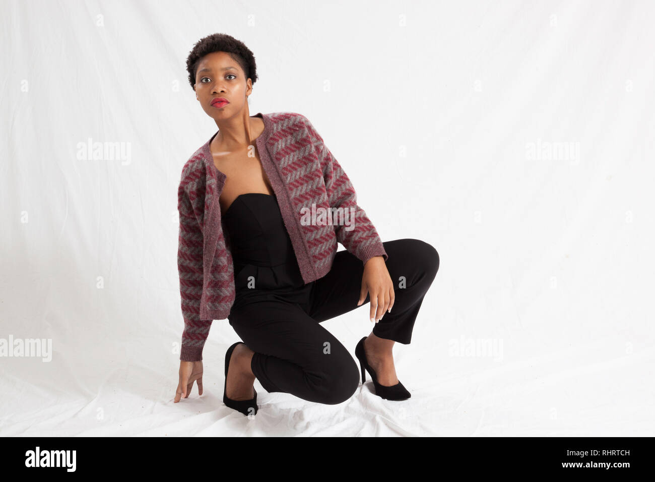Lovely Black woman squatting thoughtfully Stock Photo - Alamy