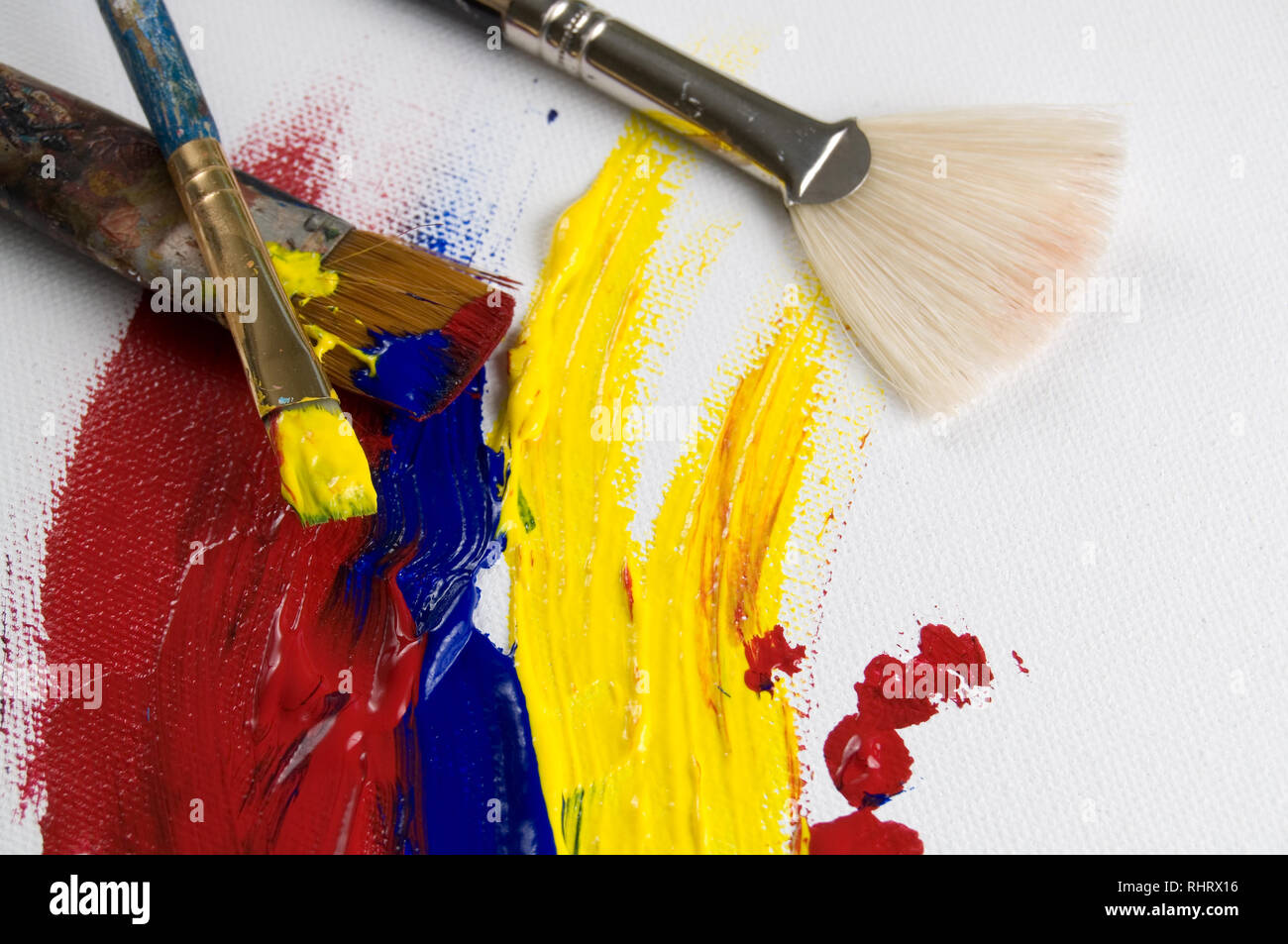 Beautiful Red, Blue and Yellow Paint and Brushes on White Canvas Stock ...