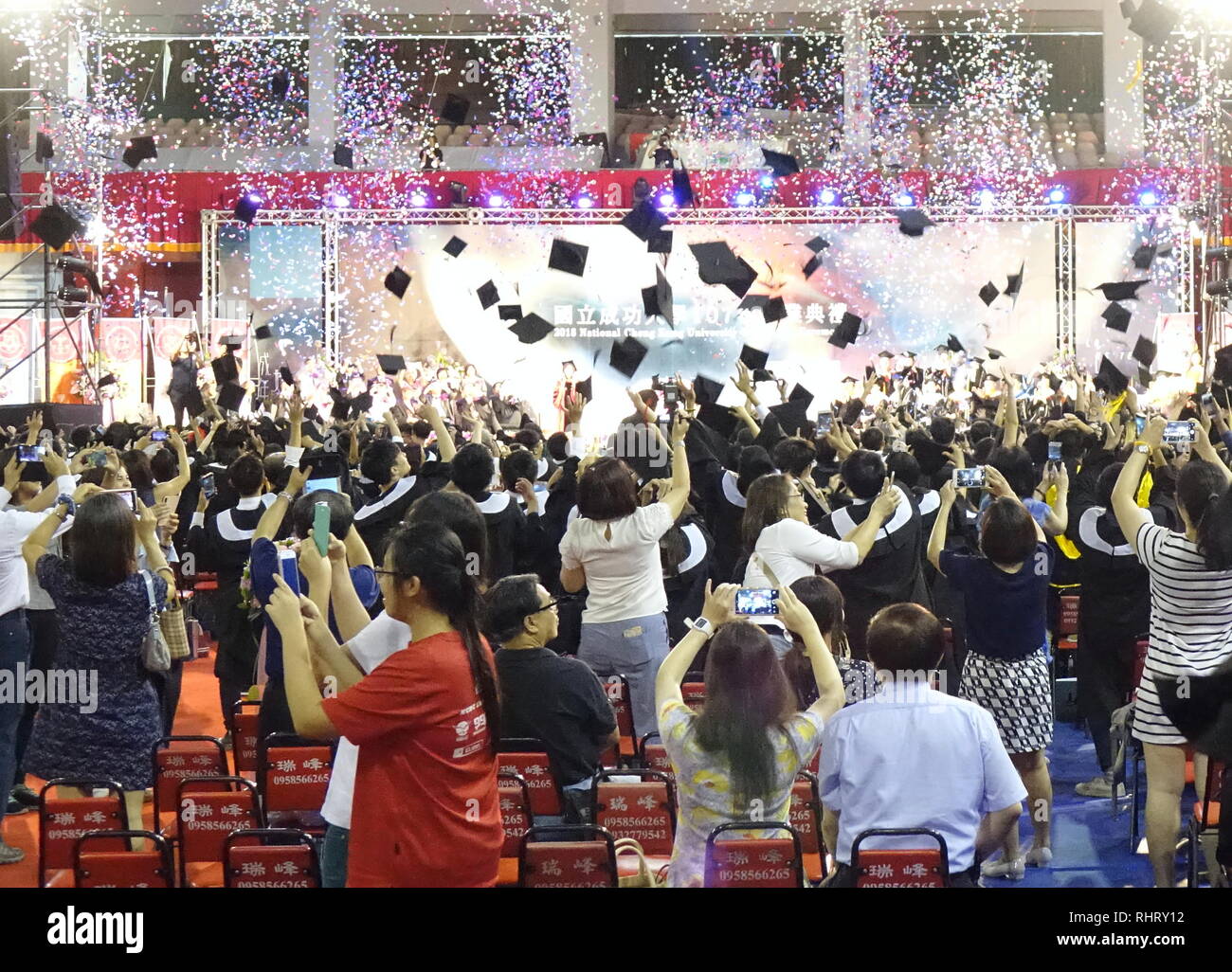 TAINAN, TAIWAN -- JUNE 2, 2018: Graduates throw their caps into the air ...