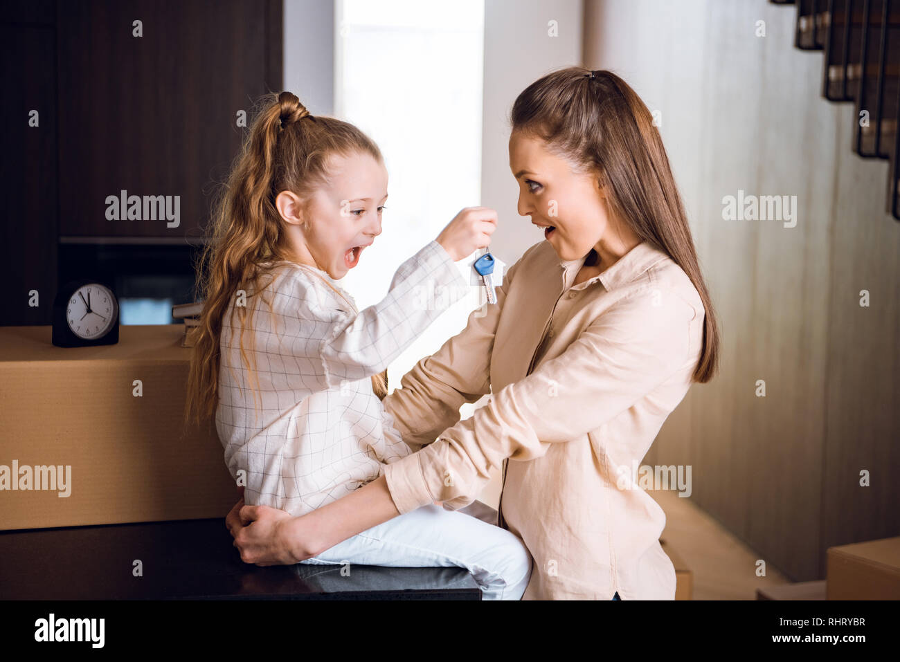 excited kid looking at keys and hugging with happy mother Stock Photo ...
