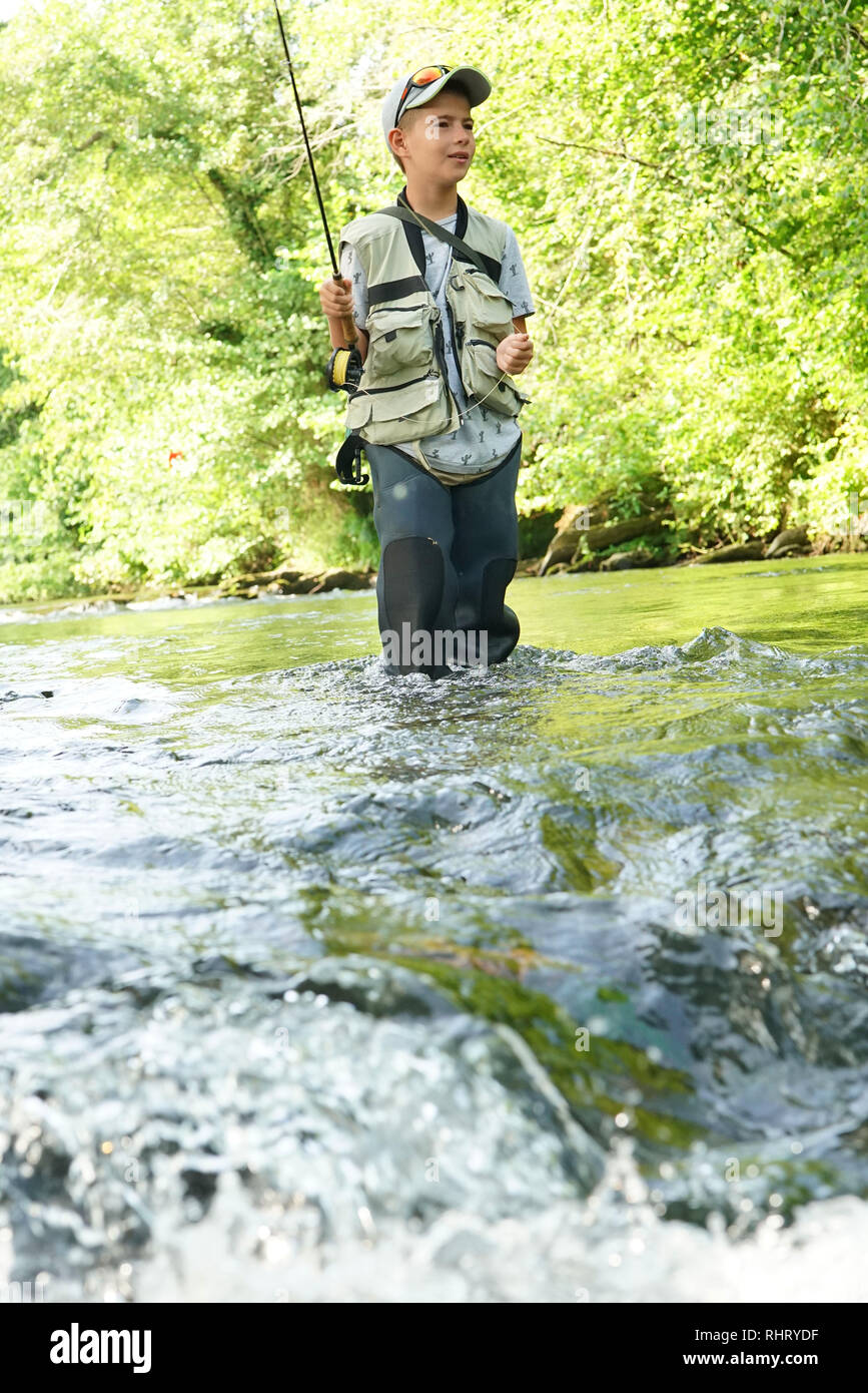 Young boy fly-fishing in river Stock Photo - Alamy
