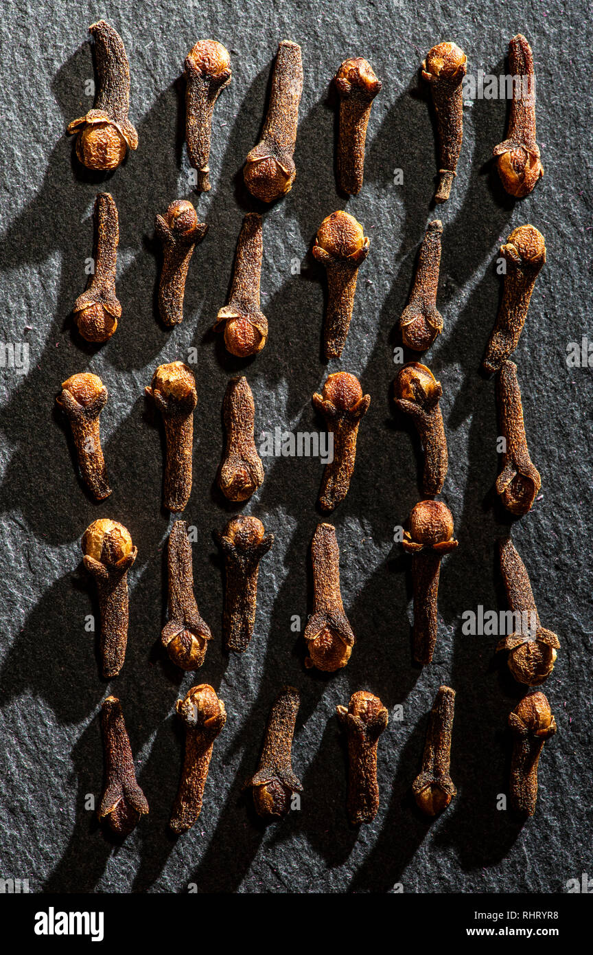 Dried Cloves on dark stone background. Natural hard light. Spice cloves ...