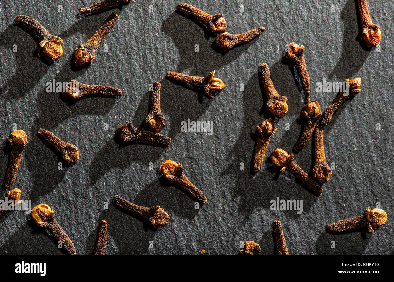 Dried Cloves on dark stone background. Natural hard light. Spice cloves ...