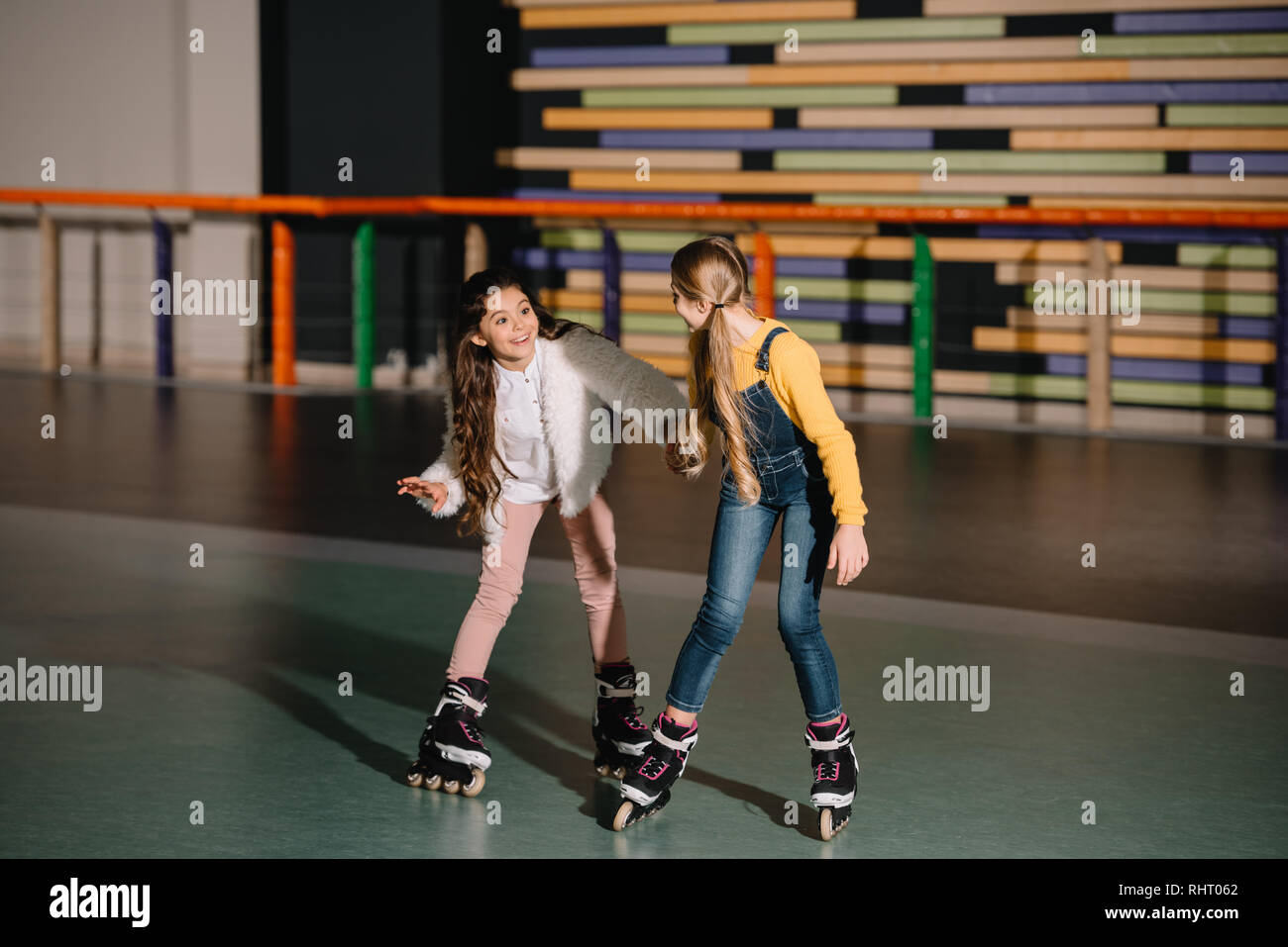 Two smiling long haired friends preparing to start moving on roller ...