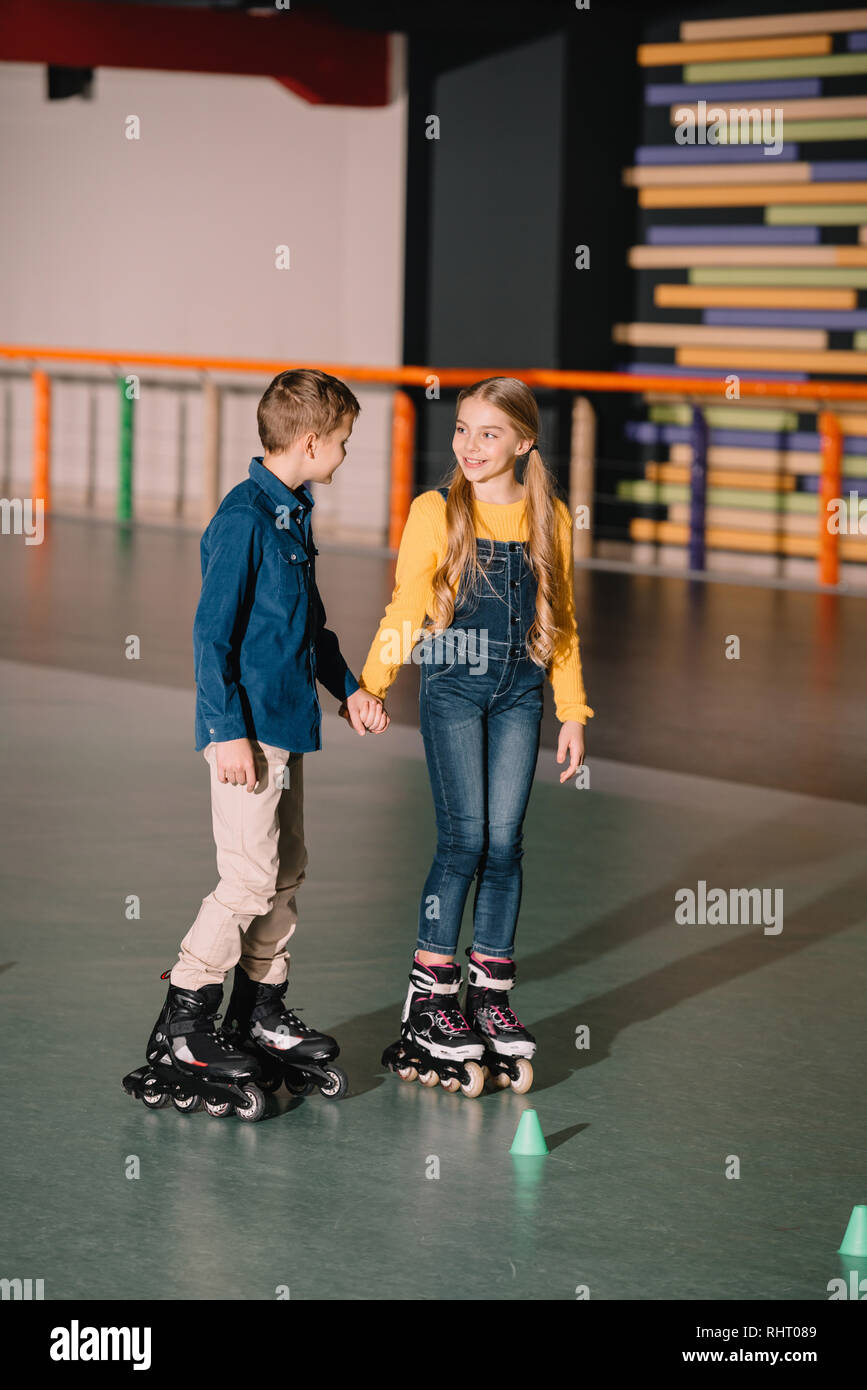 Beautiful smiling skating and holding hands Stock Photo - Alamy