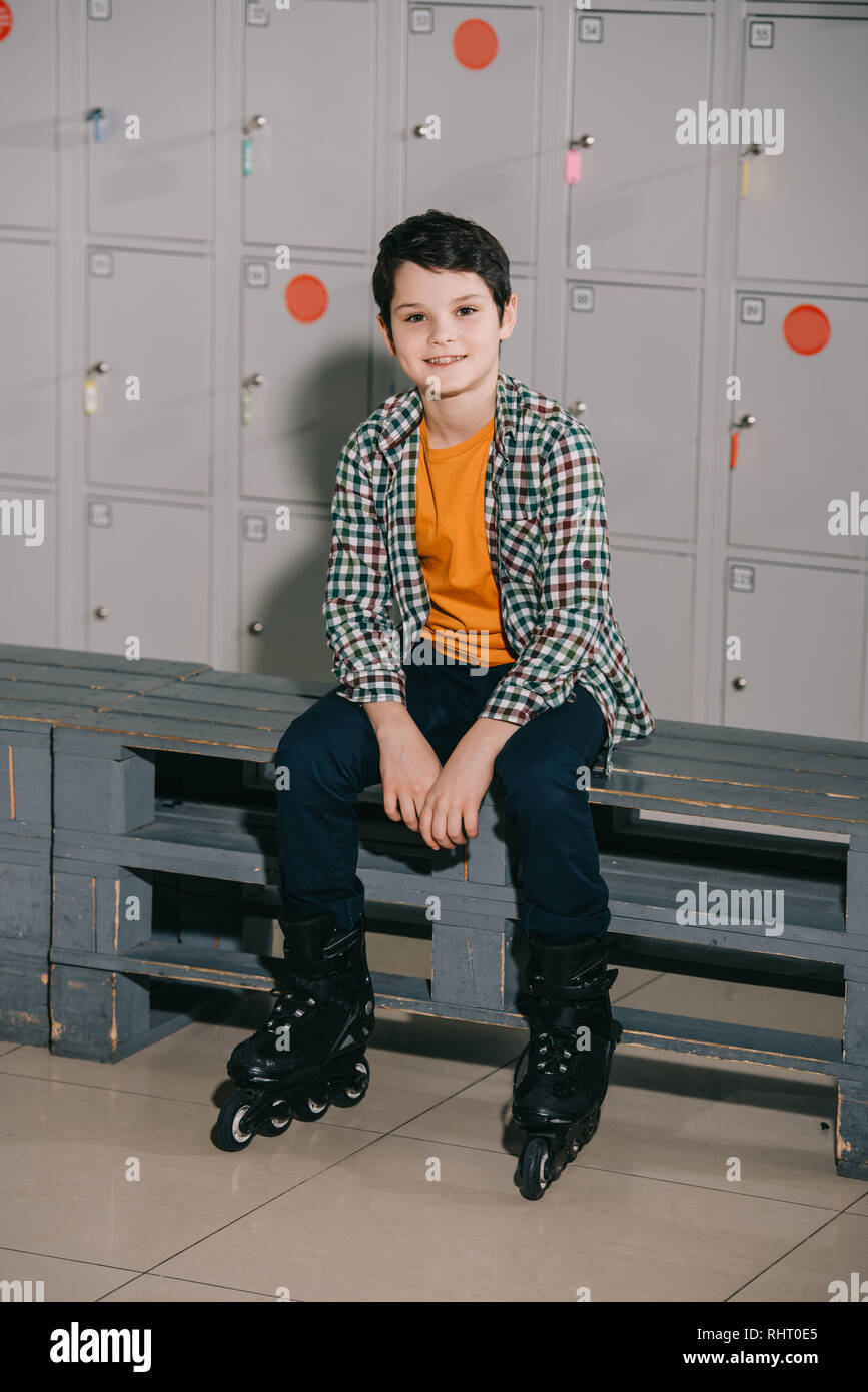 Cute brunette boy in checkered shirt posing in roller skates Stock ...