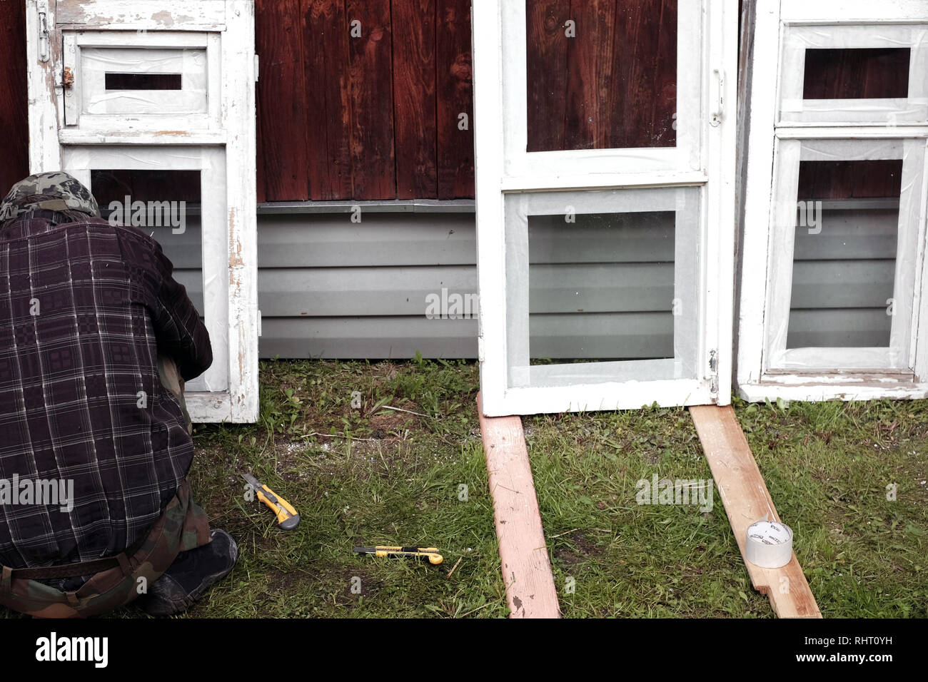A worker siting outdoor and fixing dismounted window frames Stock Photo ...