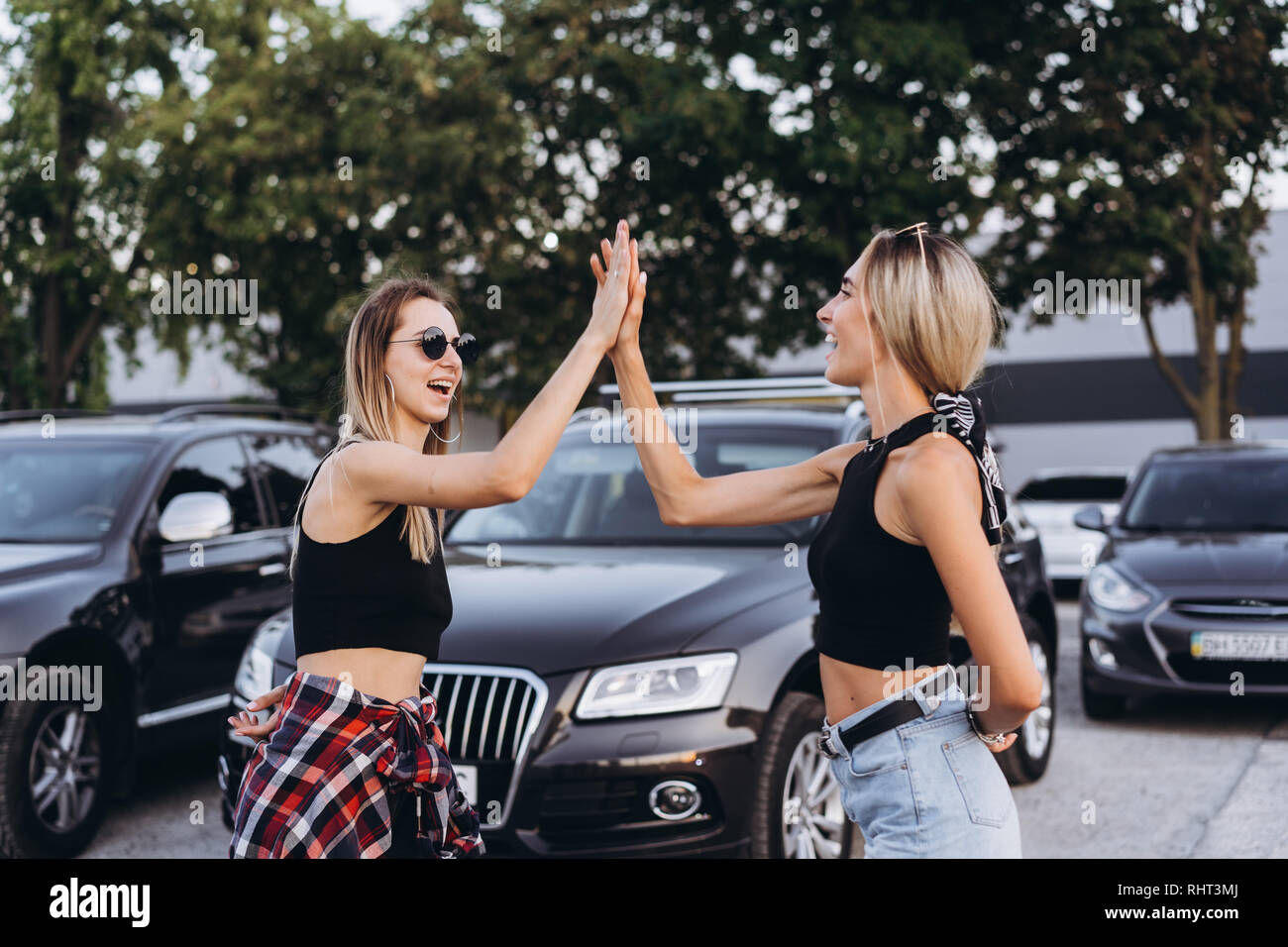 Two girls met in the car parking Stock Photo - Alamy