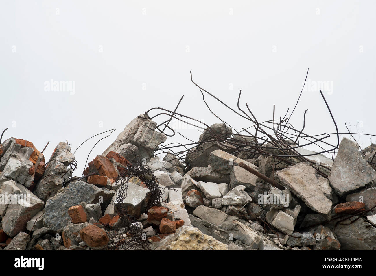 The rebar sticking up from piles of brick rubble, stone and concrete ...