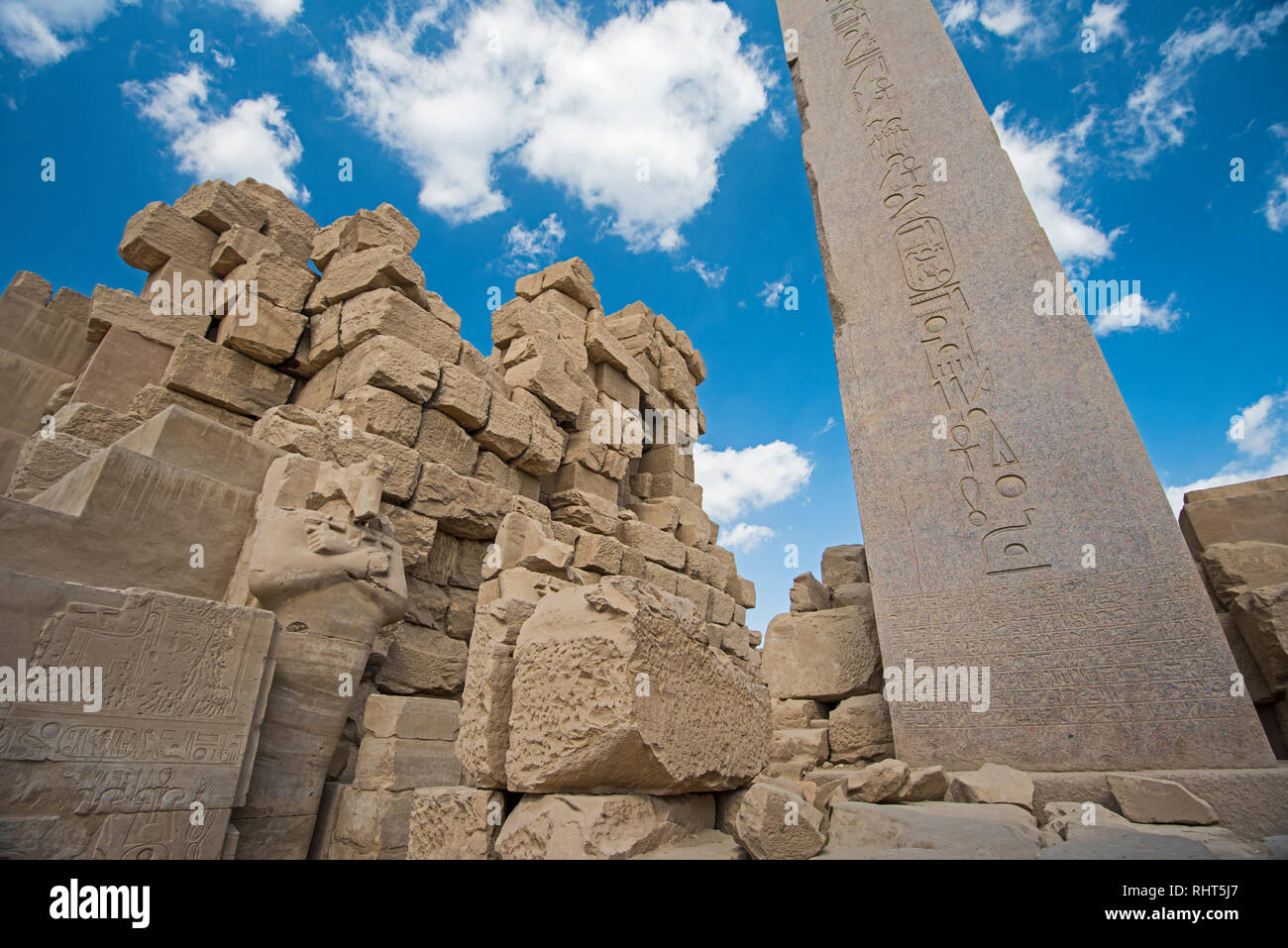 Large tall ancient egyptian obelisk at the temple of Karnak in Luxor with hieroglyphic carvings ...