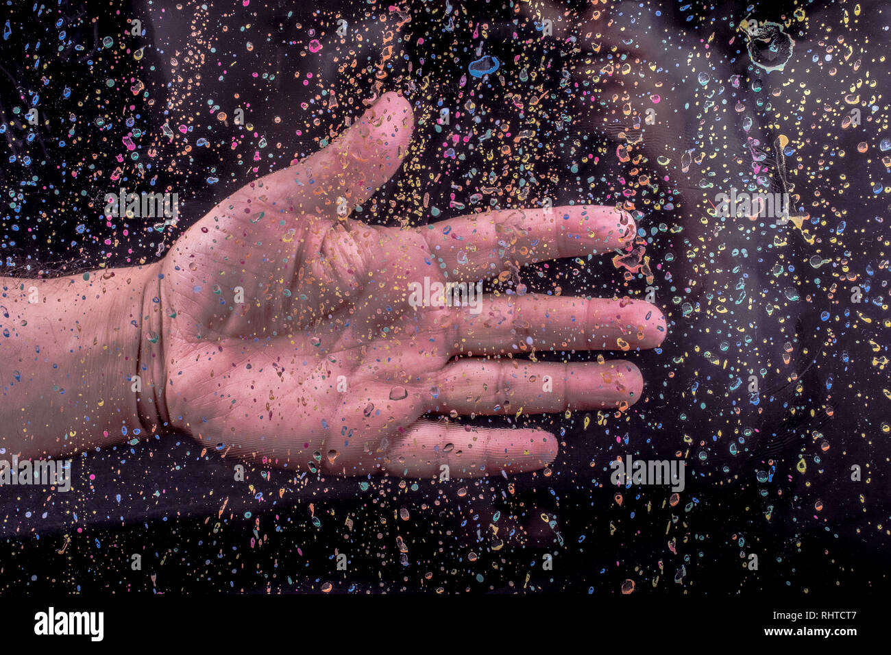 Hand on a glass with a paint splash effect on a black background Stock ...