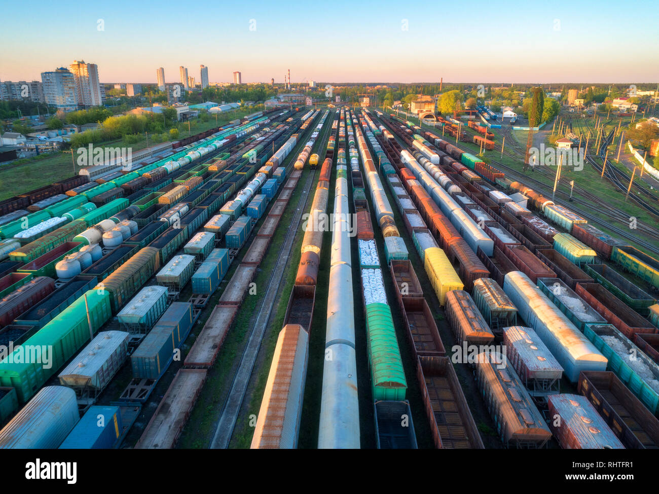 Aerial view of colorful freight trains on railway station at sunset ...