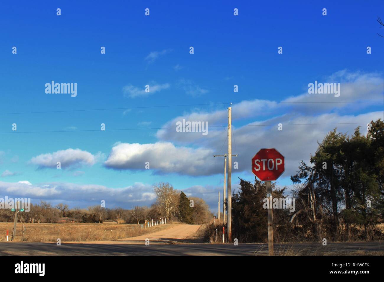 Kansas Country Road with a Stop Sign,blue sky, and white clouds out in ...