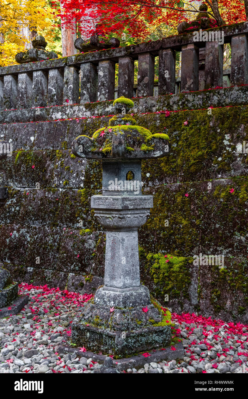 a stone latern at a temple in Nikko, Japan covered with moos and ...
