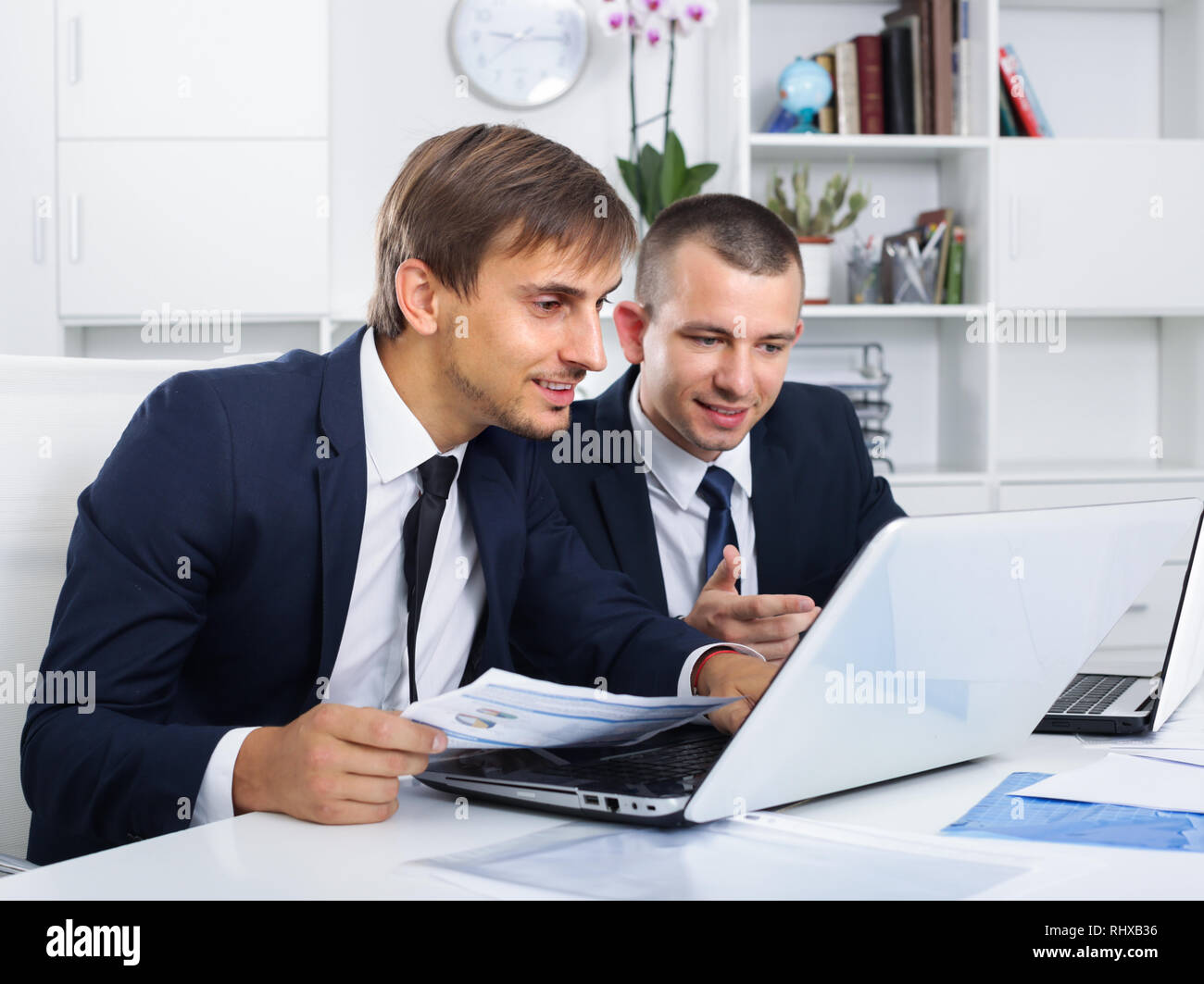 two friendly smiling business male assistants wearing formalwear ...